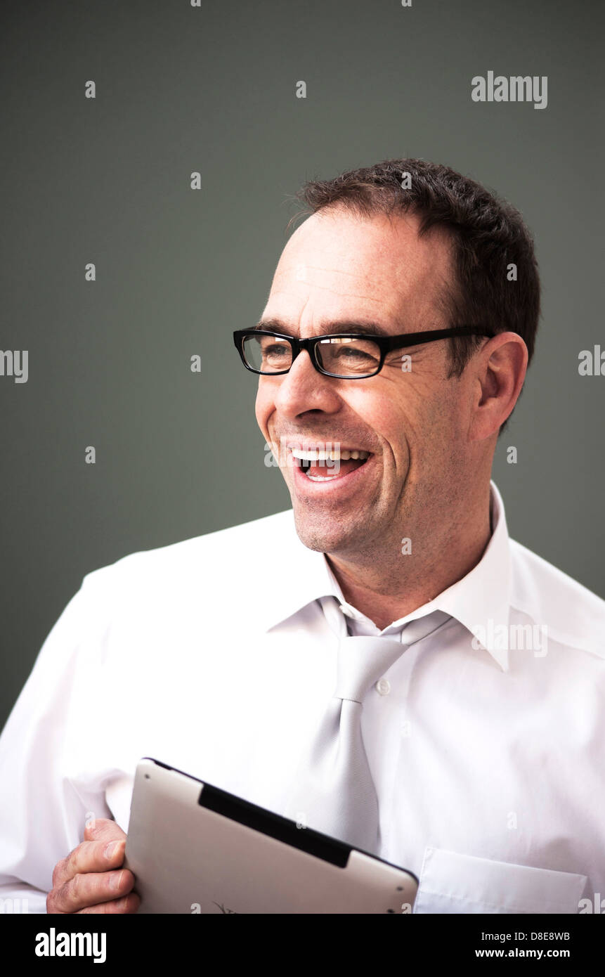 Laughing businessman using tablet pc Stock Photo - Alamy