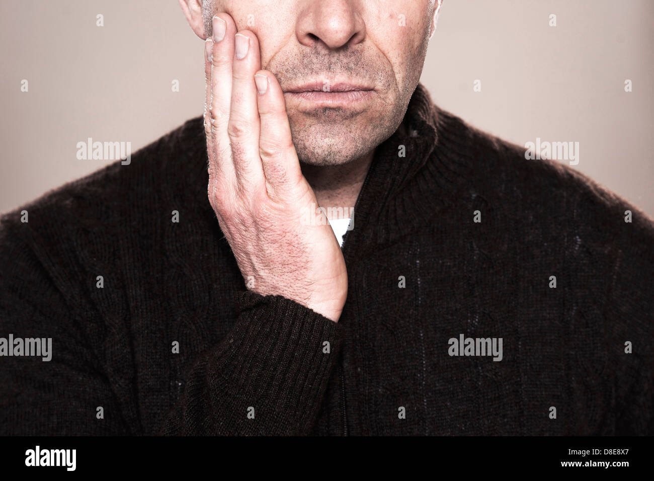 Serious man touching his cheek, close-up Stock Photo - Alamy