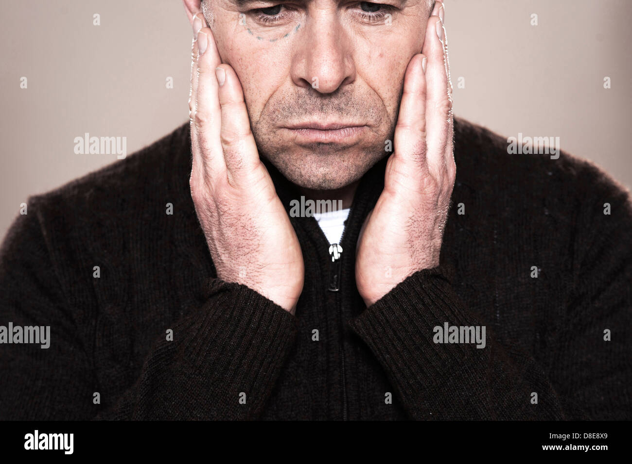 Serious man touching his cheek, close-up Stock Photo - Alamy