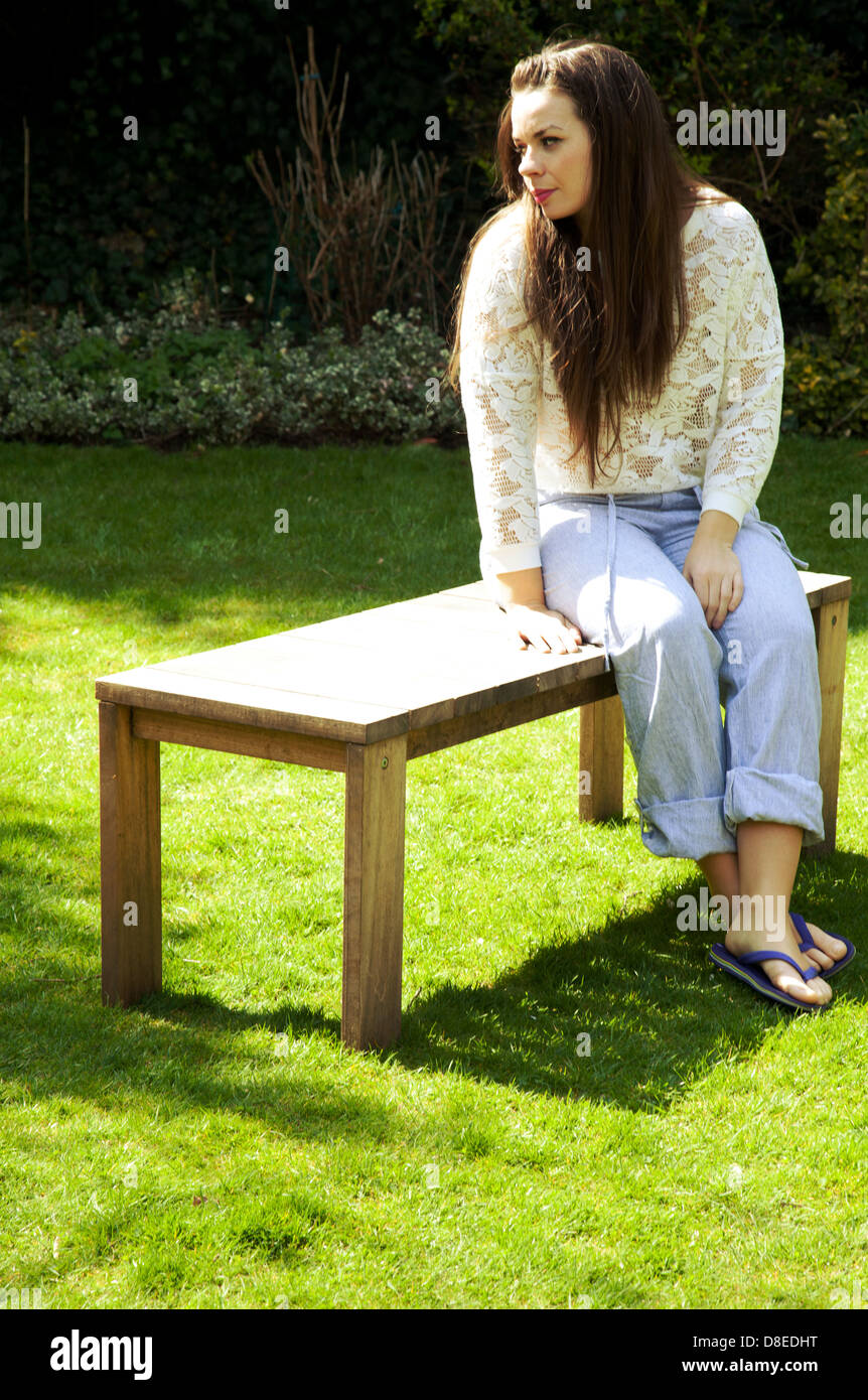 Woman Sitting on Garden Bench Stock Photo - Alamy
