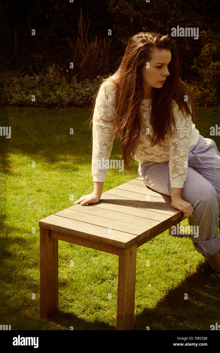 Woman Sitting on Garden Bench Stock Photo - Alamy