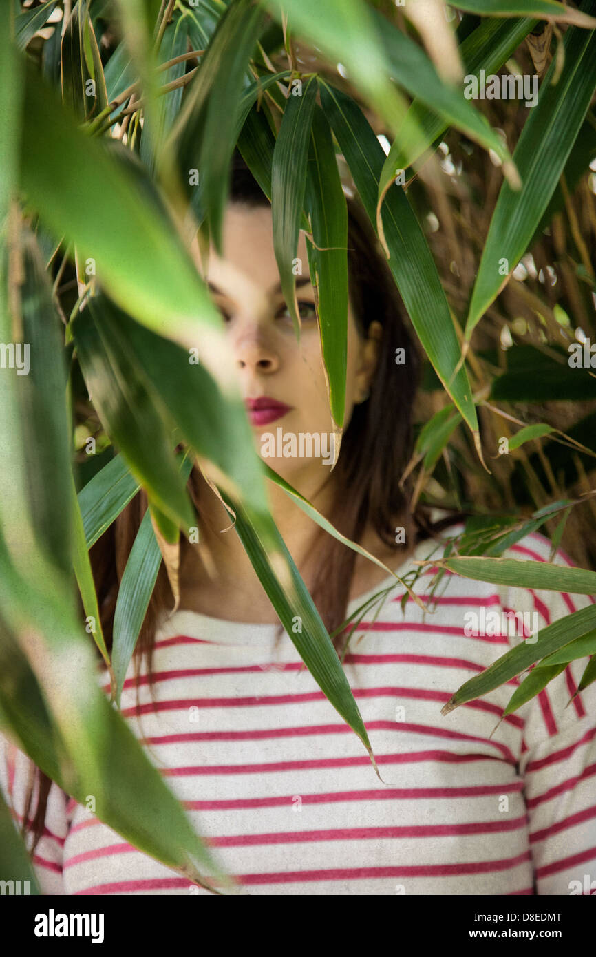 Woman Peering Through Greenery Stock Photo - Alamy