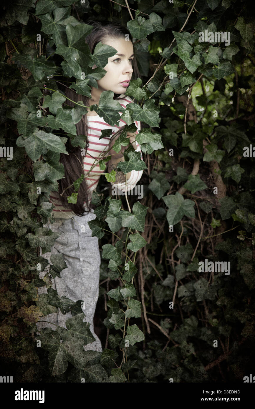 Beautiful woman peeking through tree hi-res stock photography and ...