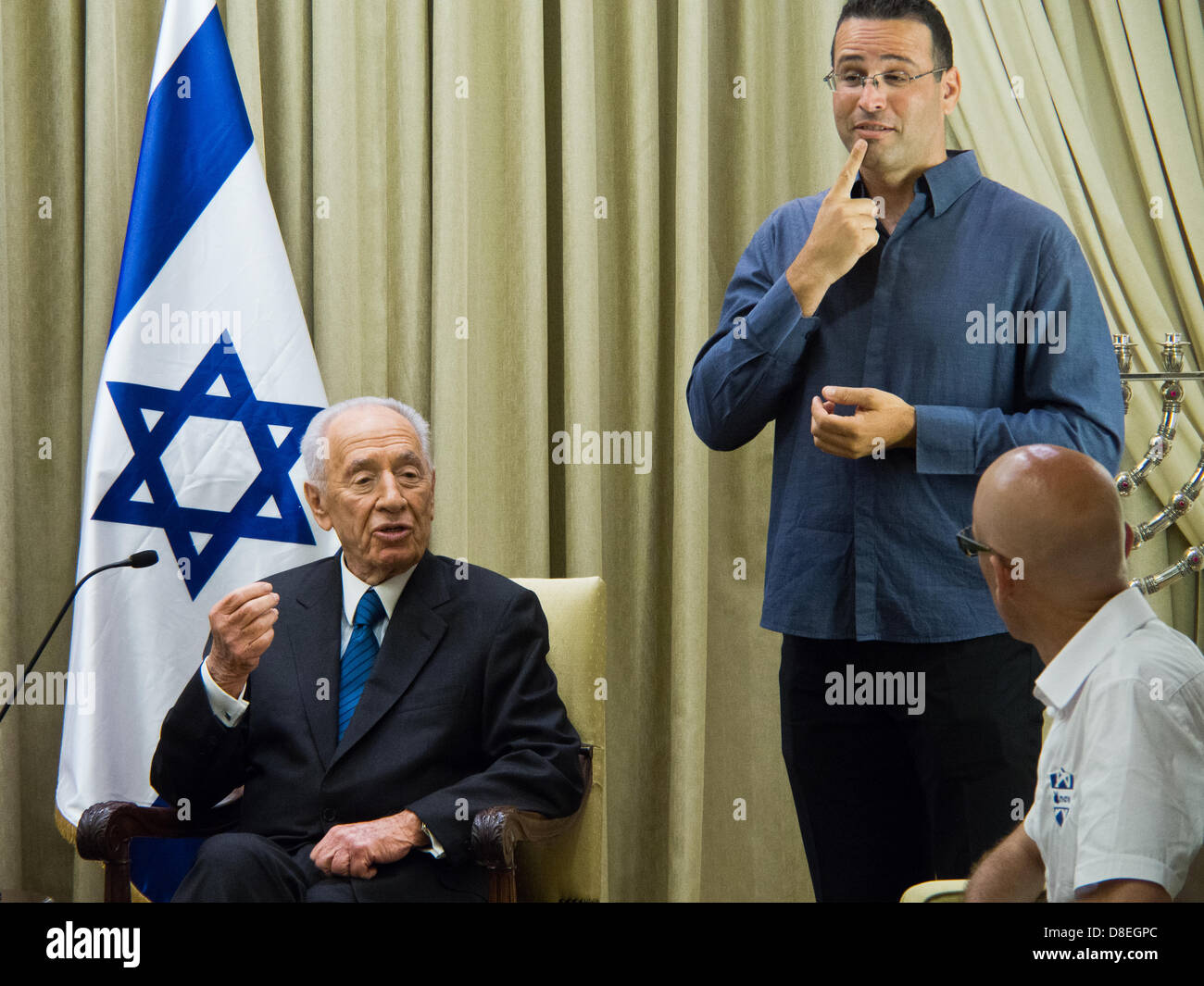 A sign-language translator translates President Shimon Peres as he ...