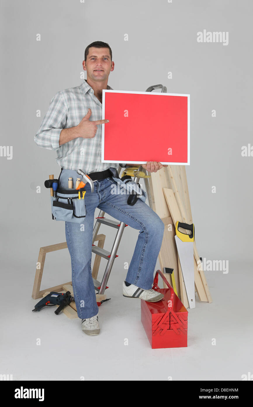 Carpenter holding a blank red sign Stock Photo - Alamy