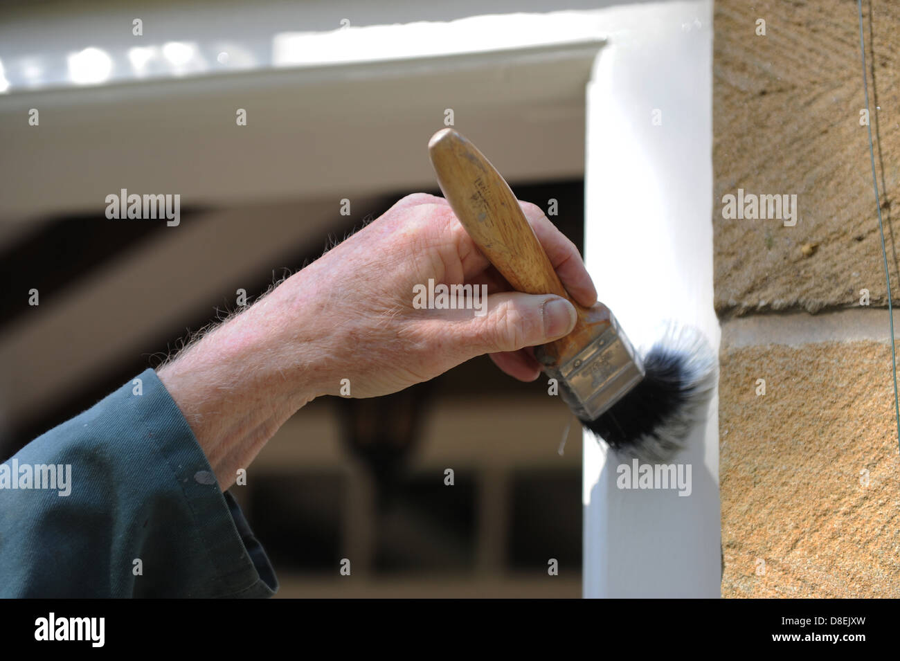 Elderly male painting the door frame on the porch of his house Stock ...