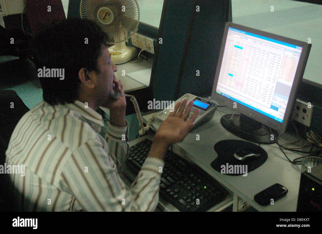 A Pakistani stockbroker busy in trading during a trading session at the ...