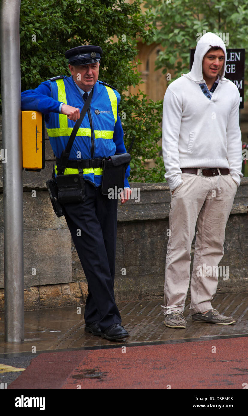 Civil Enforcement Officer and man in hoodie waiting at the traffic ...