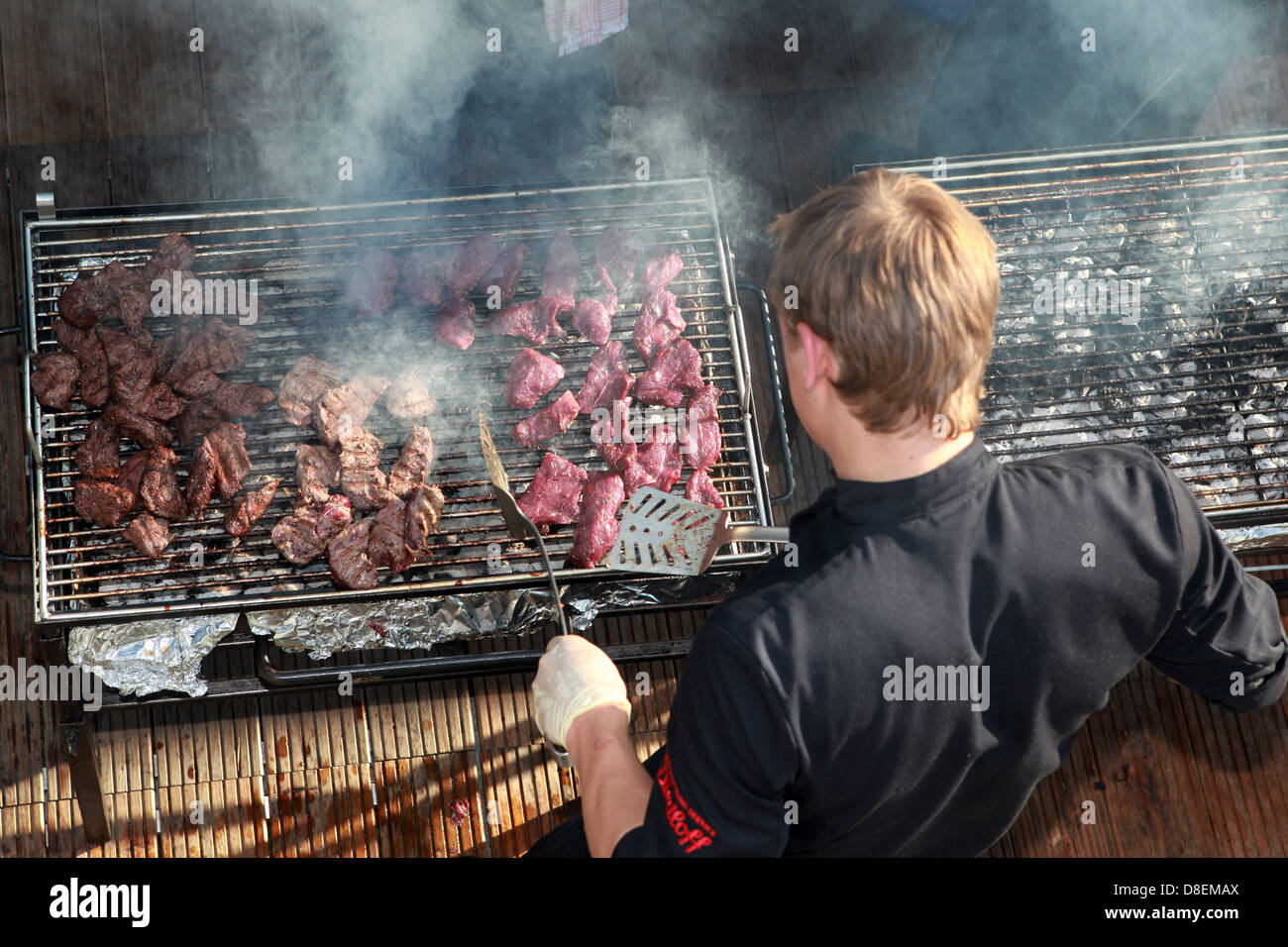 Hannover, Germany, man prepares meat on a grill Stock Photo - Alamy