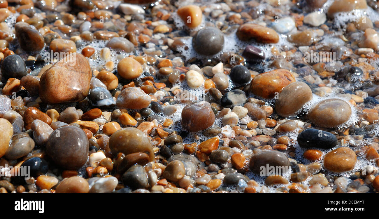 Pebbles on a beach being washed by the waves england uk Stock Photo - Alamy