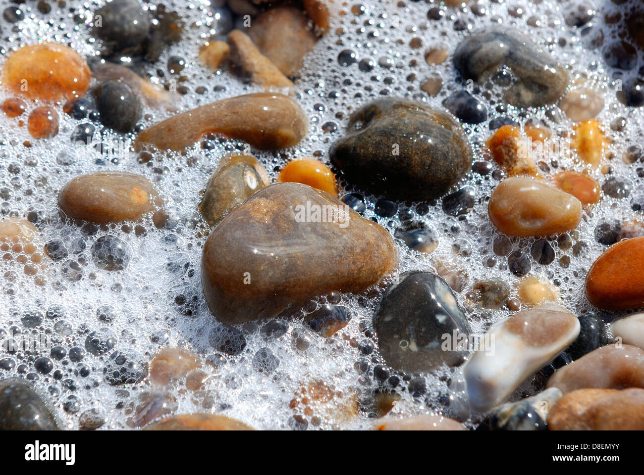 Pebbles on a beach being washed by the waves england uk Stock Photo - Alamy
