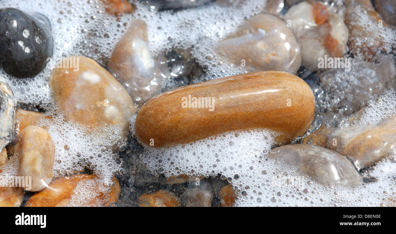 Pebbles on a beach being washed by the waves england uk Stock Photo - Alamy