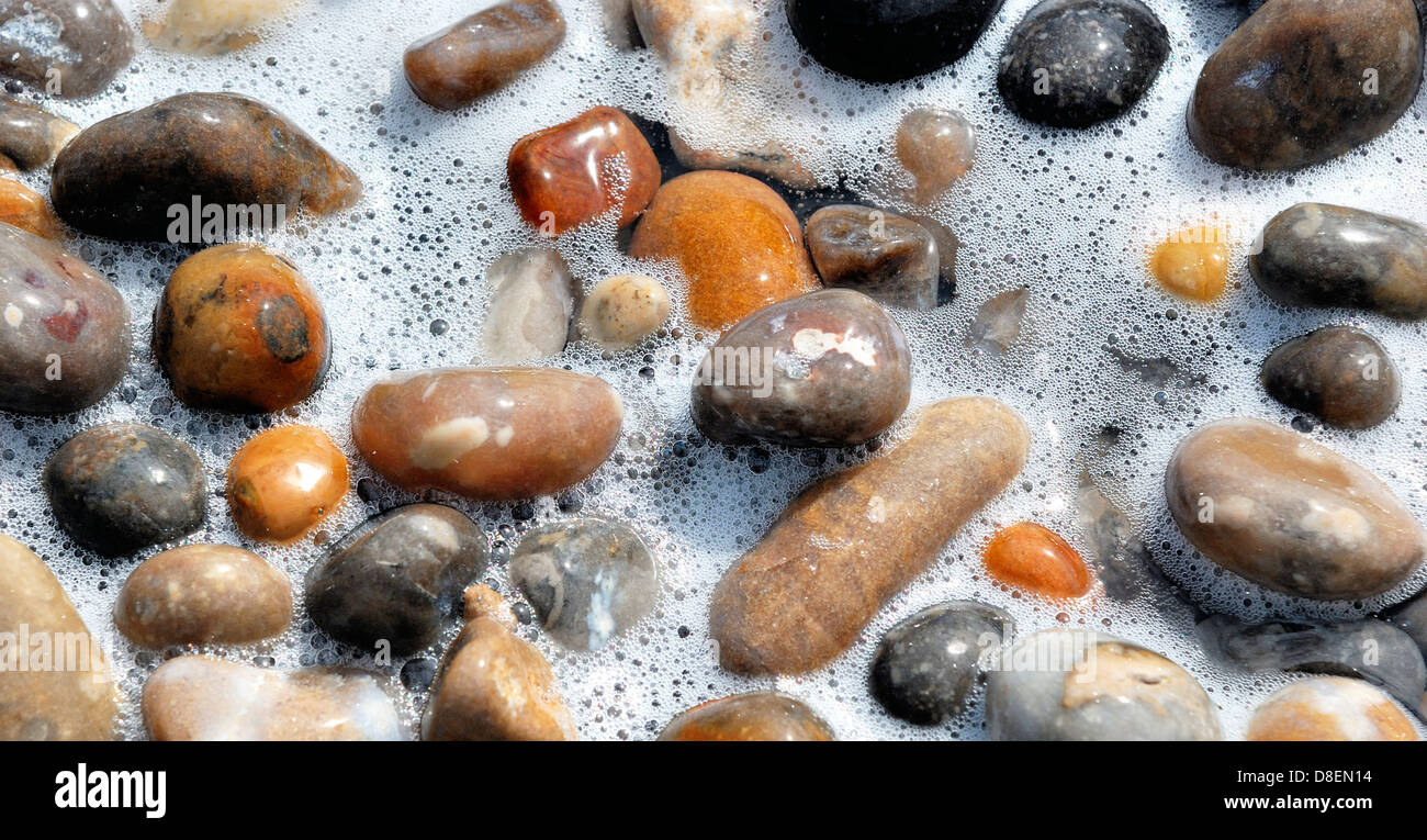 Pebbles on a beach being washed by the waves england uk Stock Photo - Alamy