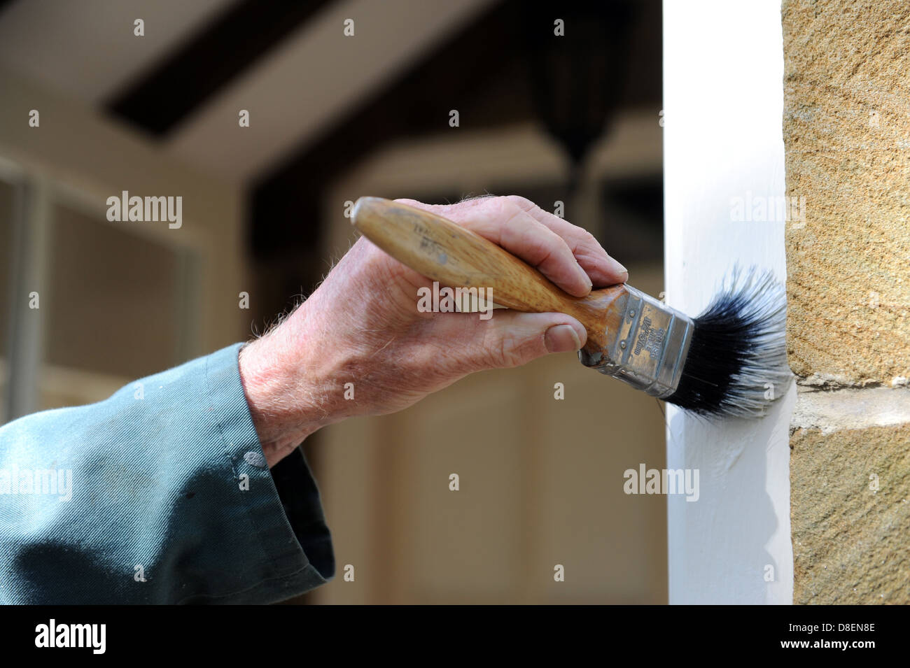 Elderly male painting the door frame on the porch of his house Stock ...