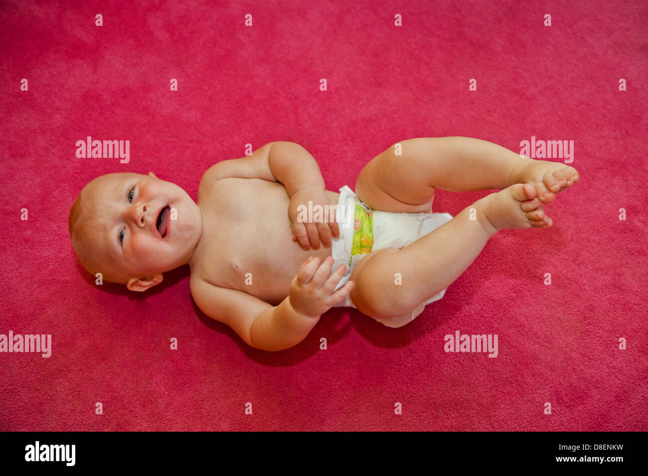 Baby on red background Stock Photo - Alamy