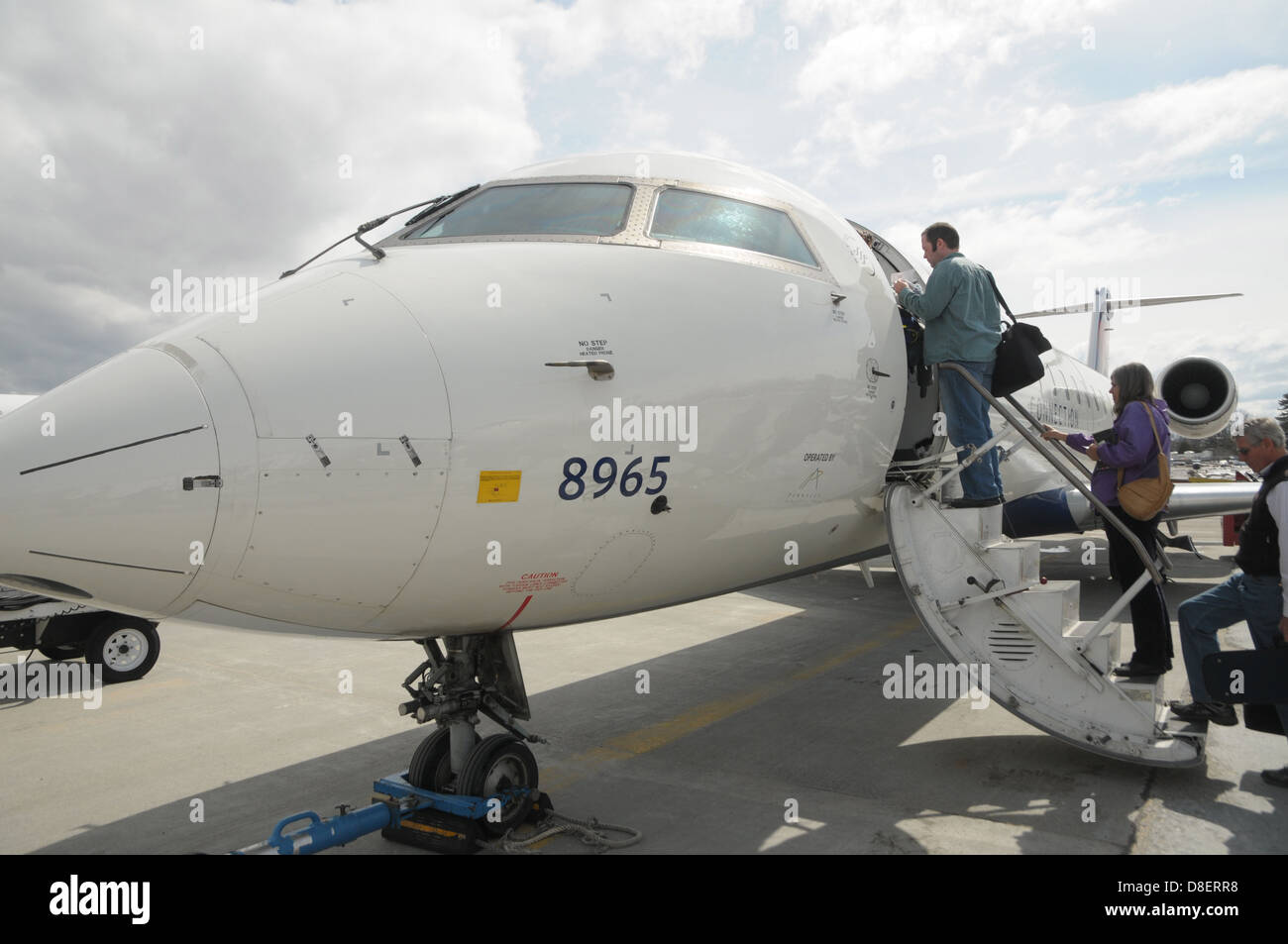 Air travelers board an airplane in Burlington, Vermont enroute to their ...