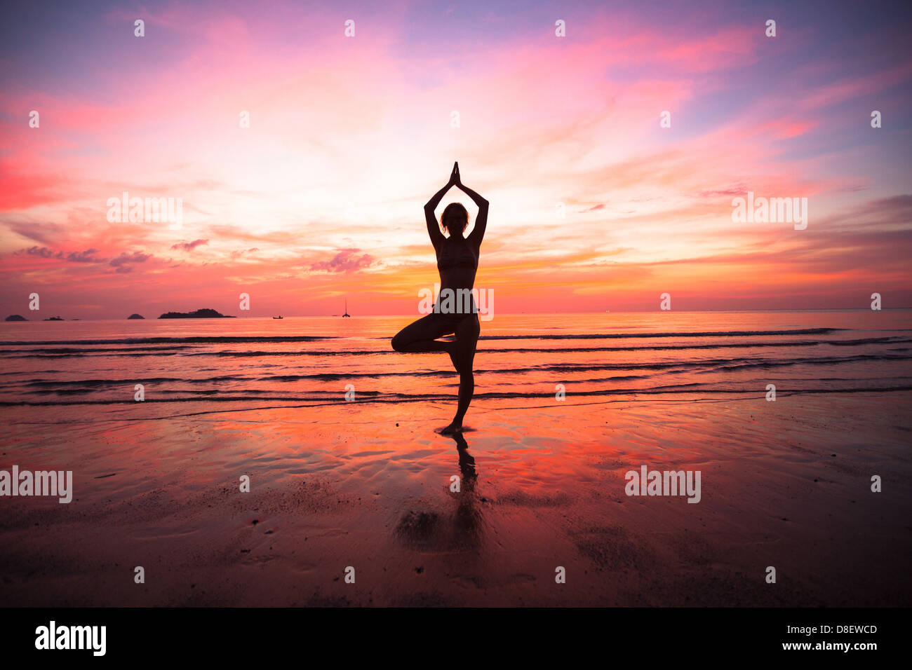 Young woman yoga practice at the seaside at sunset Stock Photo - Alamy