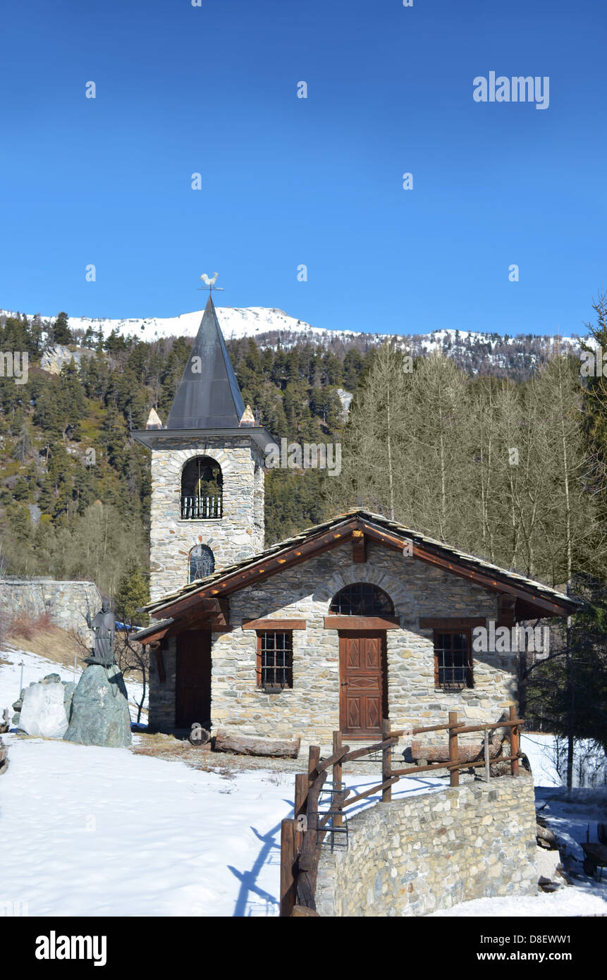 Small, rural chapel in the mountains made of stone. Snow on front yard ...