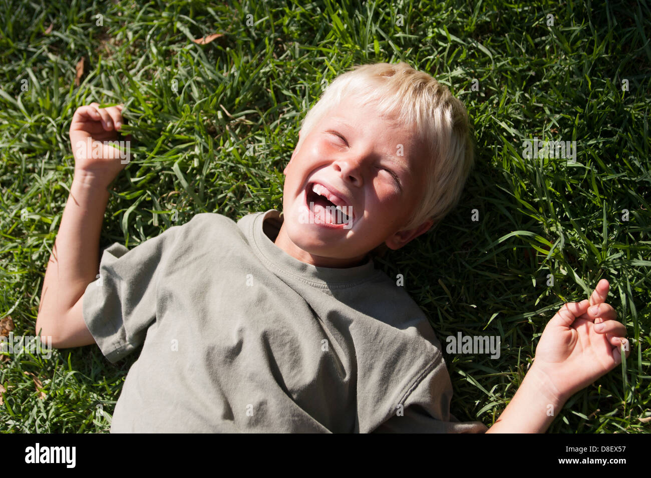 Young Boy with no front teeth lying in the grass Stock Photo - Alamy