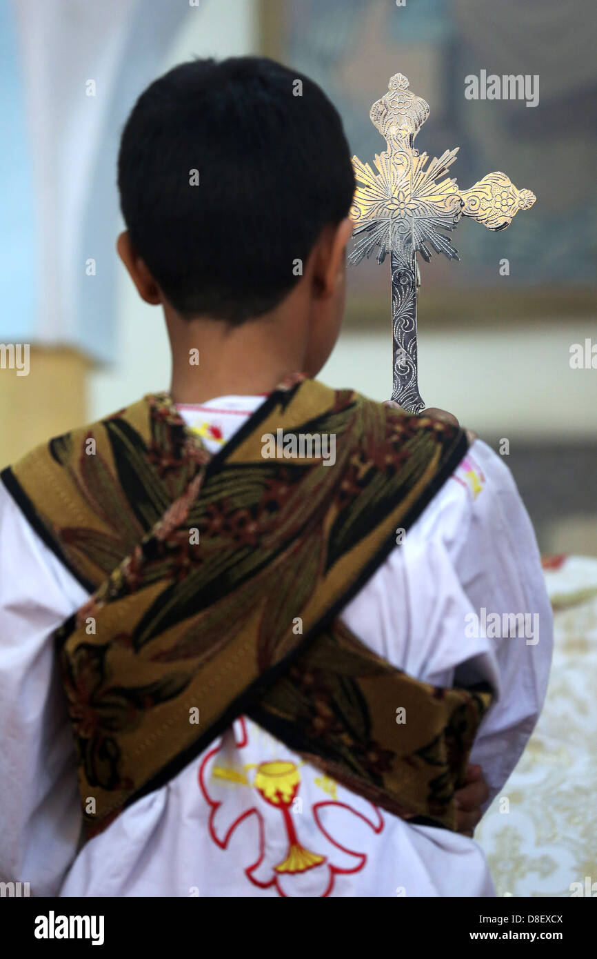 Egypt, altar boy holding cross during sunday mass service in a coptic ...