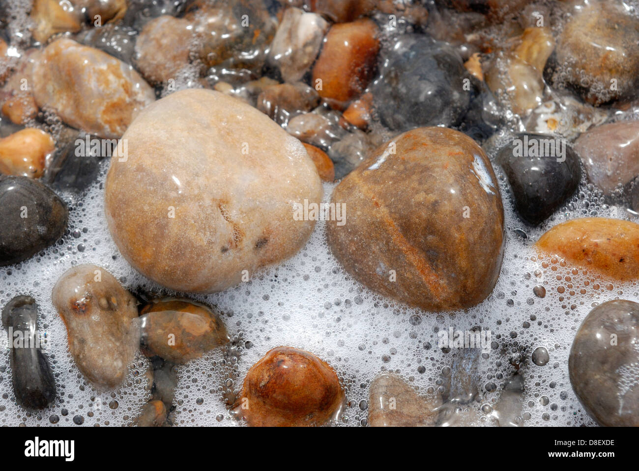 Pebbles on a beach being washed by the waves england uk Stock Photo - Alamy