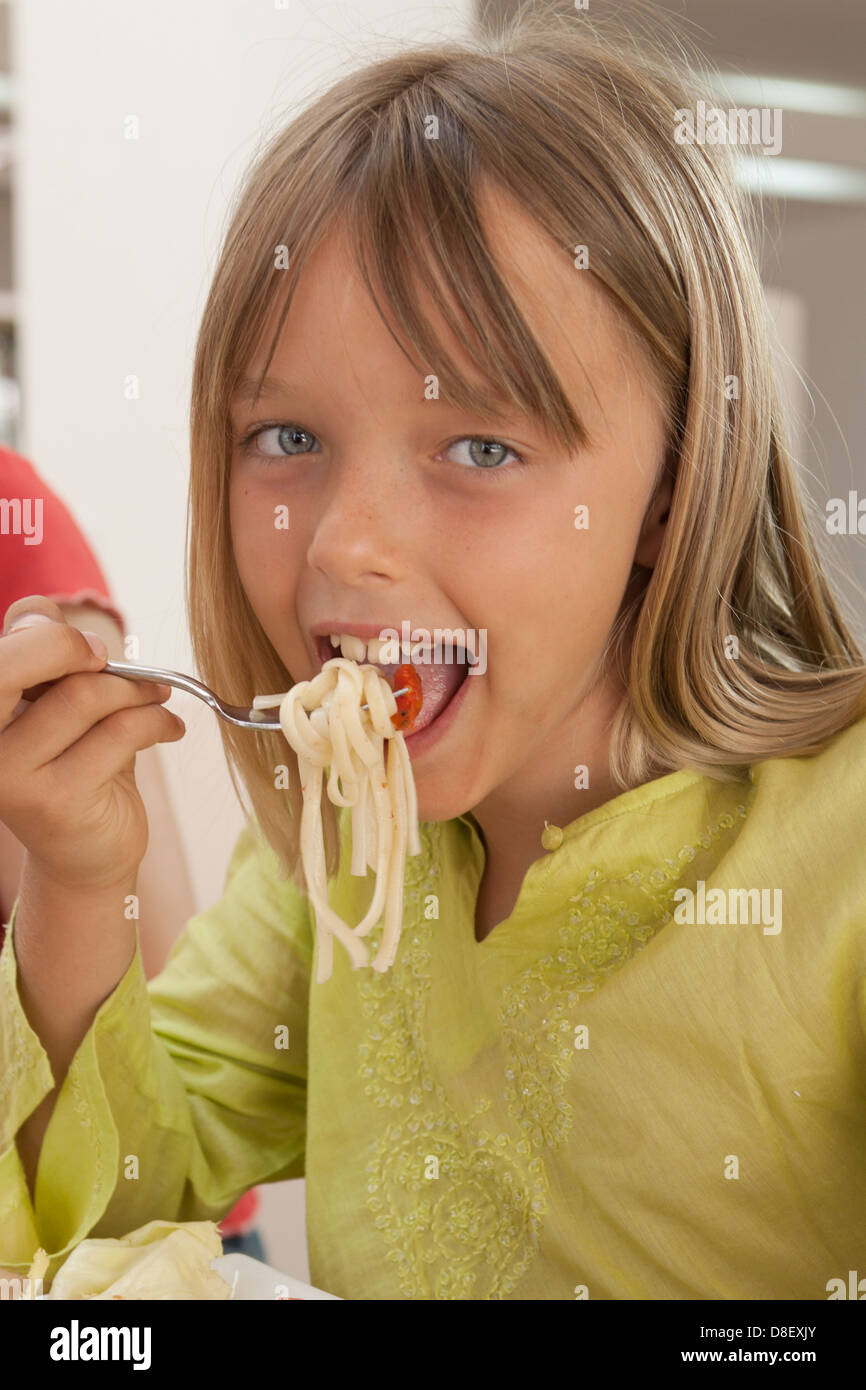 Young girl eating spaghetti Stock Photo - Alamy