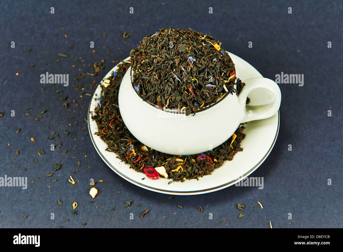 Tea cup on a dish and tea leaves Stock Photo - Alamy