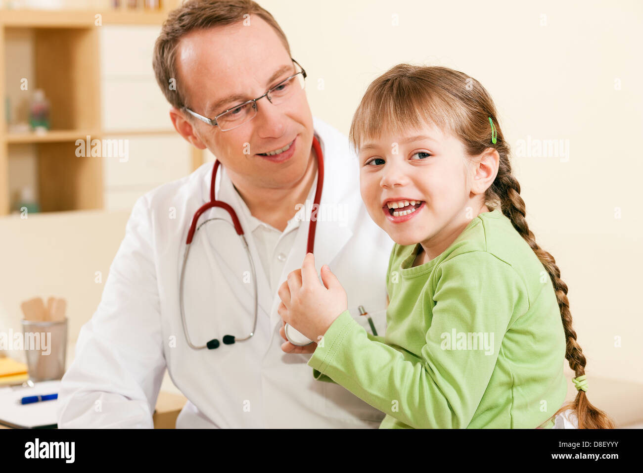 Doctor - Pediatrician - with a child patient in his practice, she is ...