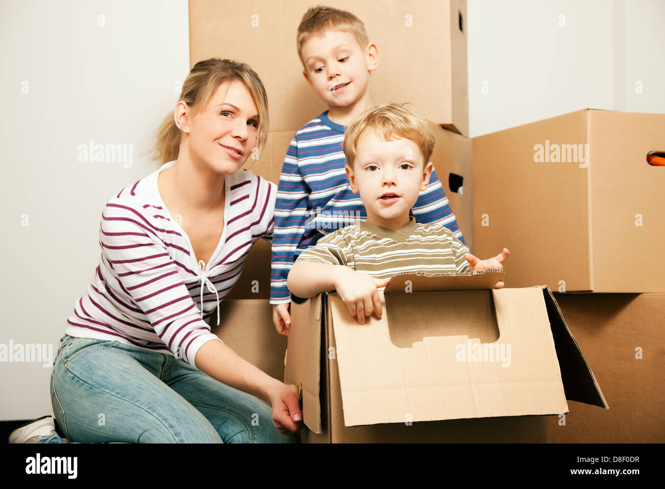 Family moving in their new house. The sons are sitting inside the ...