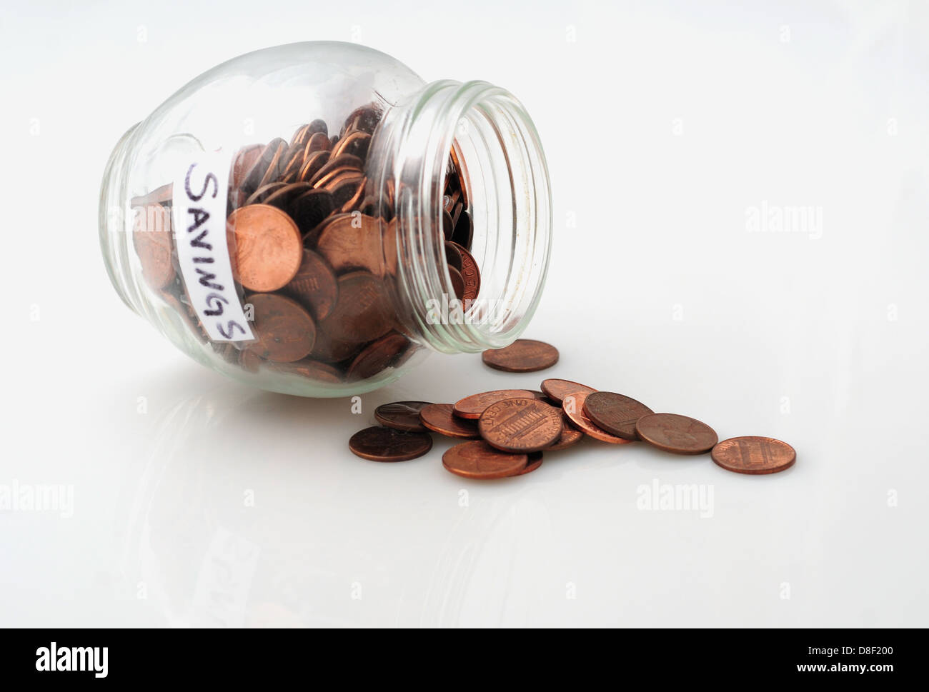Pennies spilling out of a jar of pennies to signify dipping into ...