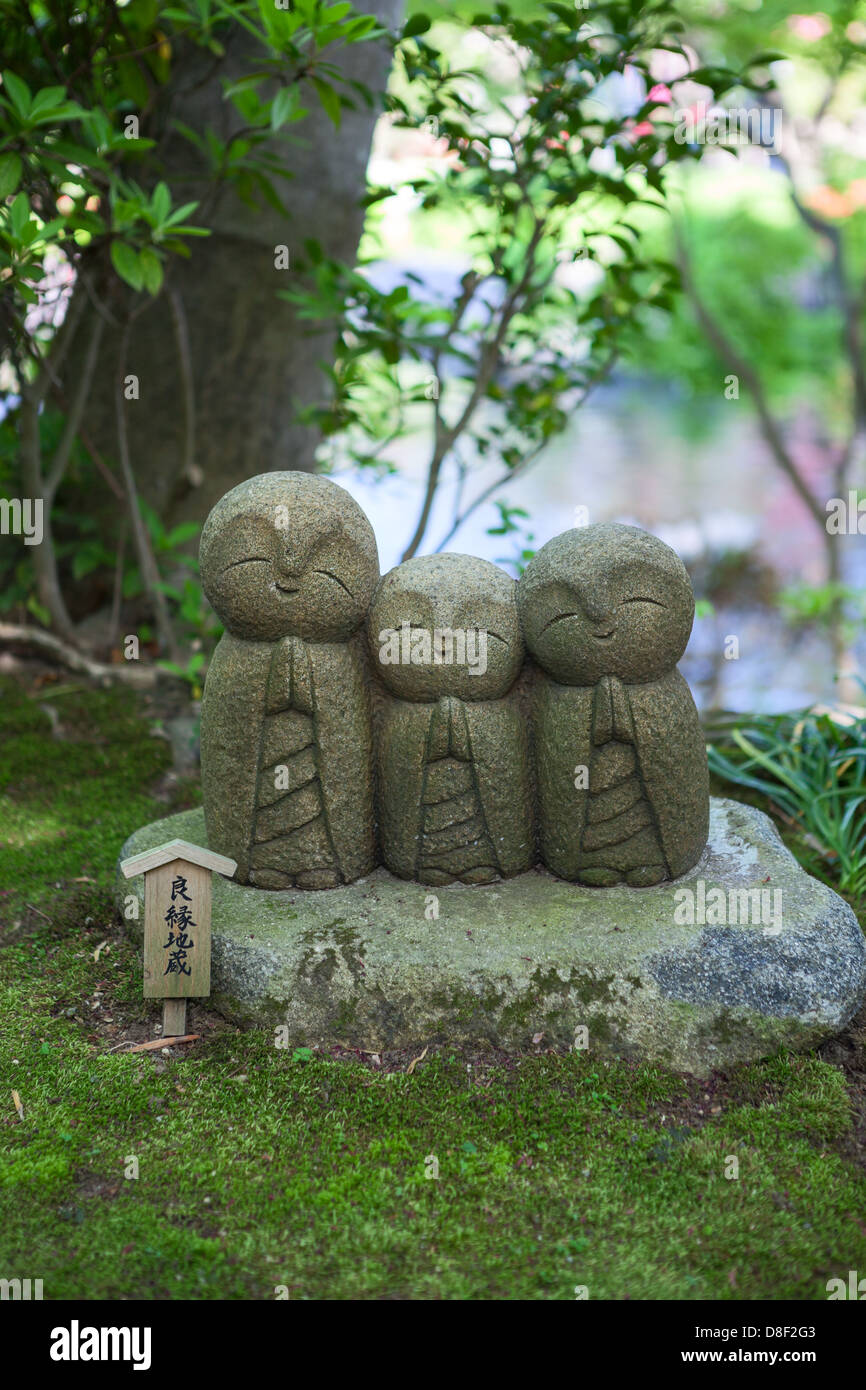 Three little stone praying Buddhas in gardens of Hasedera shrine ...