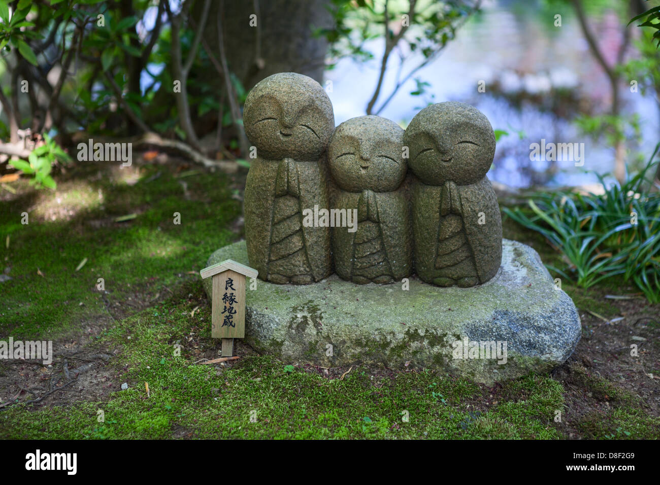 Three little stone praying Buddhas in gardens of Hasedera shrine ...