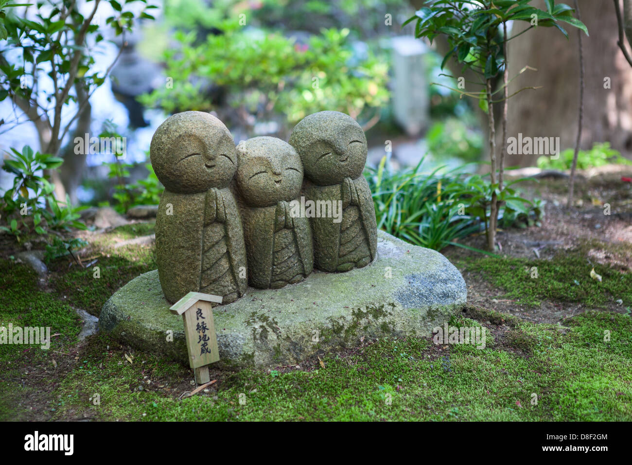 Three little stone praying Buddhas in gardens of Hasedera shrine ...