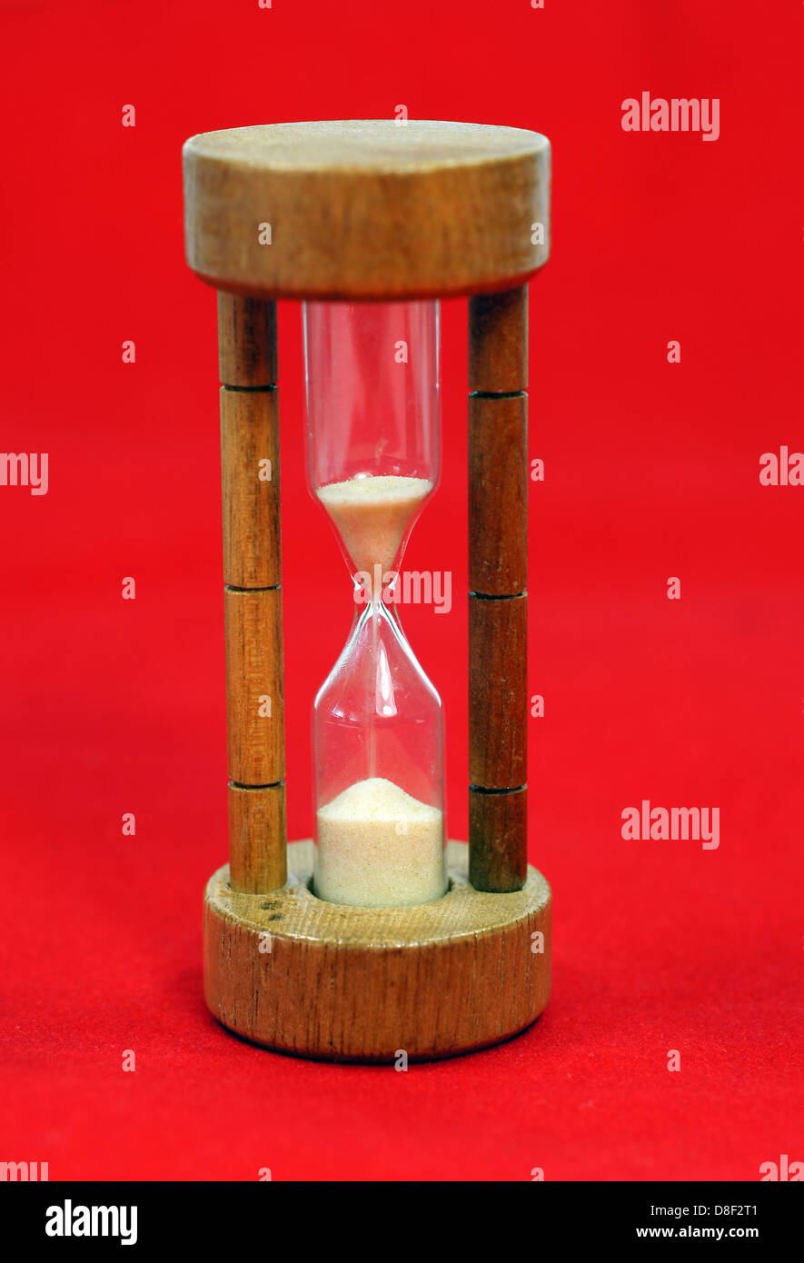 Sand timer with isolated red background Stock Photo - Alamy
