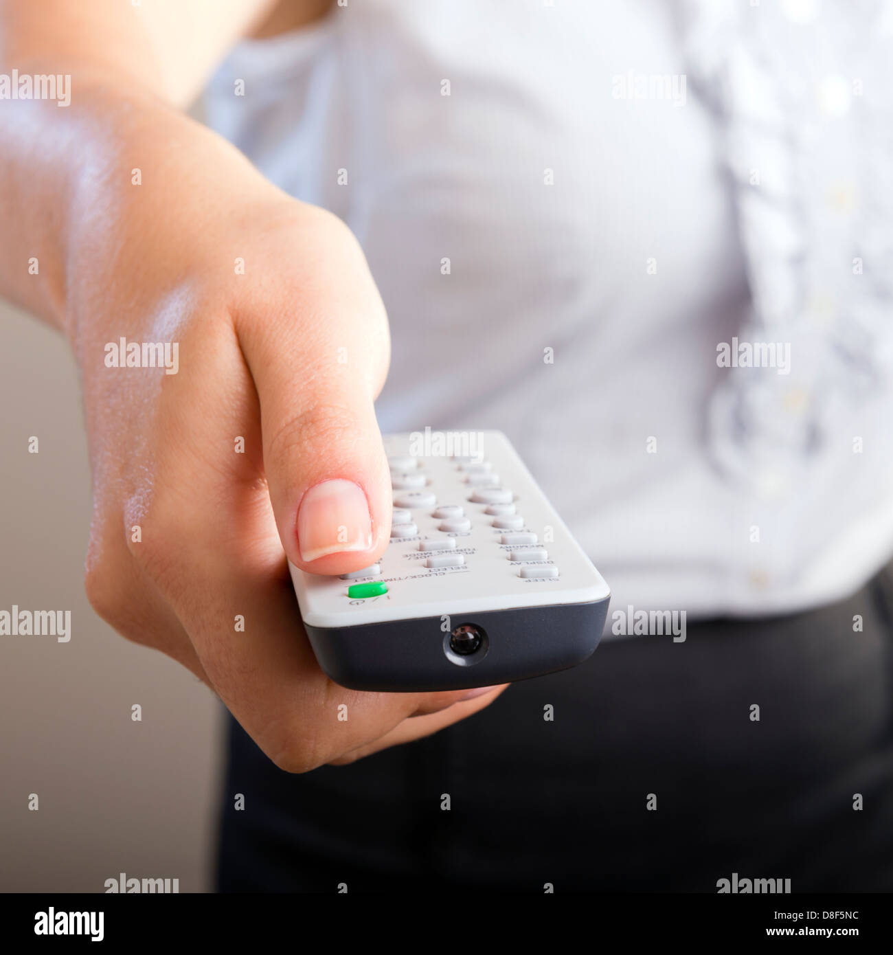 Business woman holds a remote control in her hands with her body out of ...