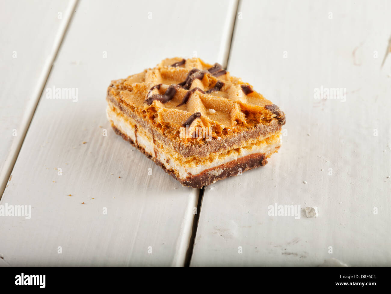 Single biscuit over a white wooden table Stock Photo - Alamy