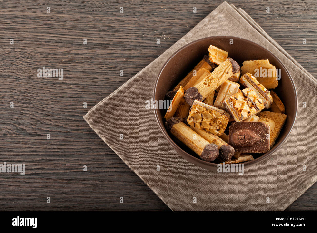 A brown cup full of biscuits over a wooden table Stock Photo - Alamy