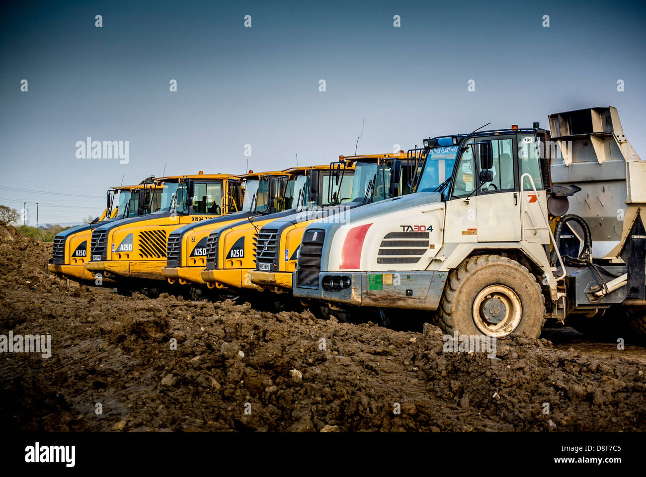 Row of dump trucks on site ready to take away excavated soil from a ...