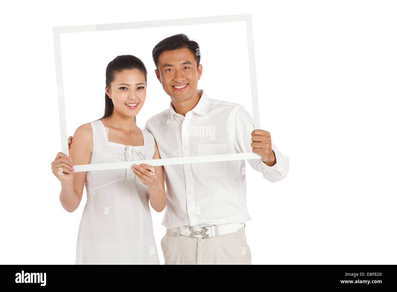 Young couple holding photo frame Stock Photo - Alamy