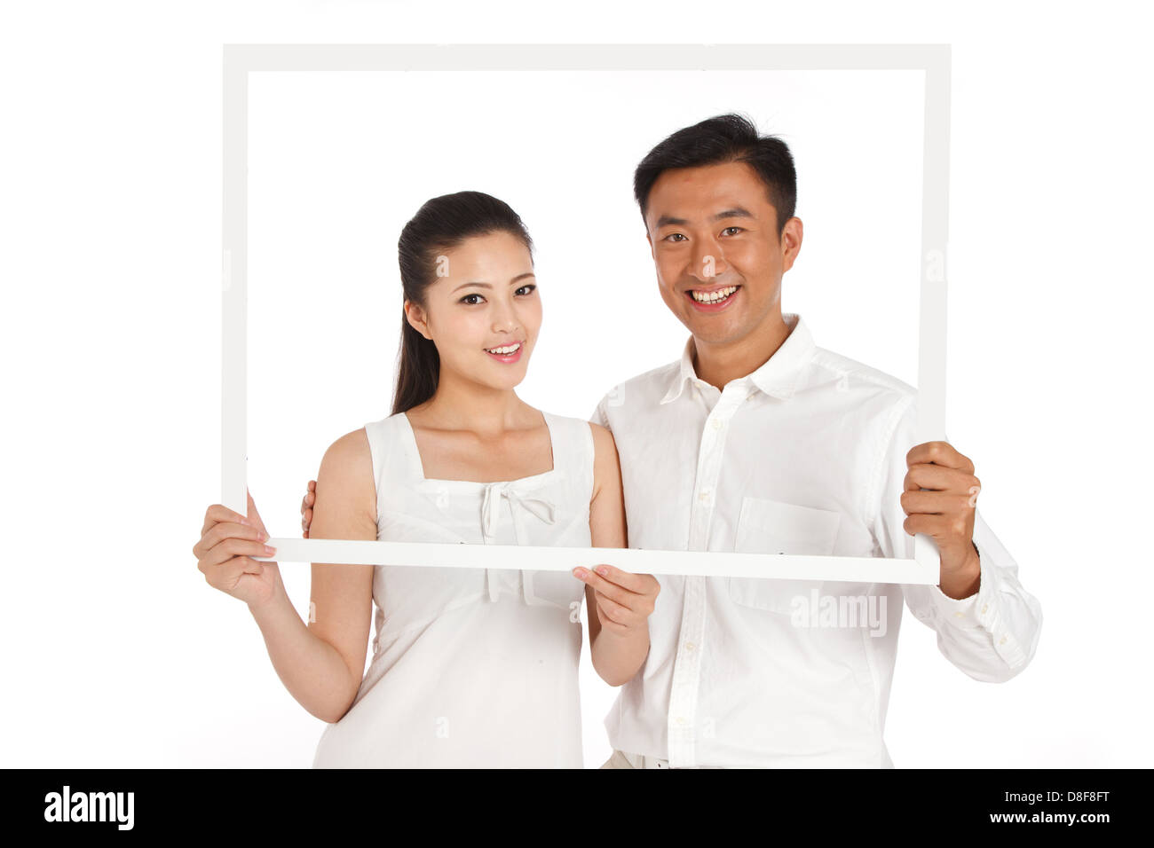 Young couple holding photo frame Stock Photo - Alamy