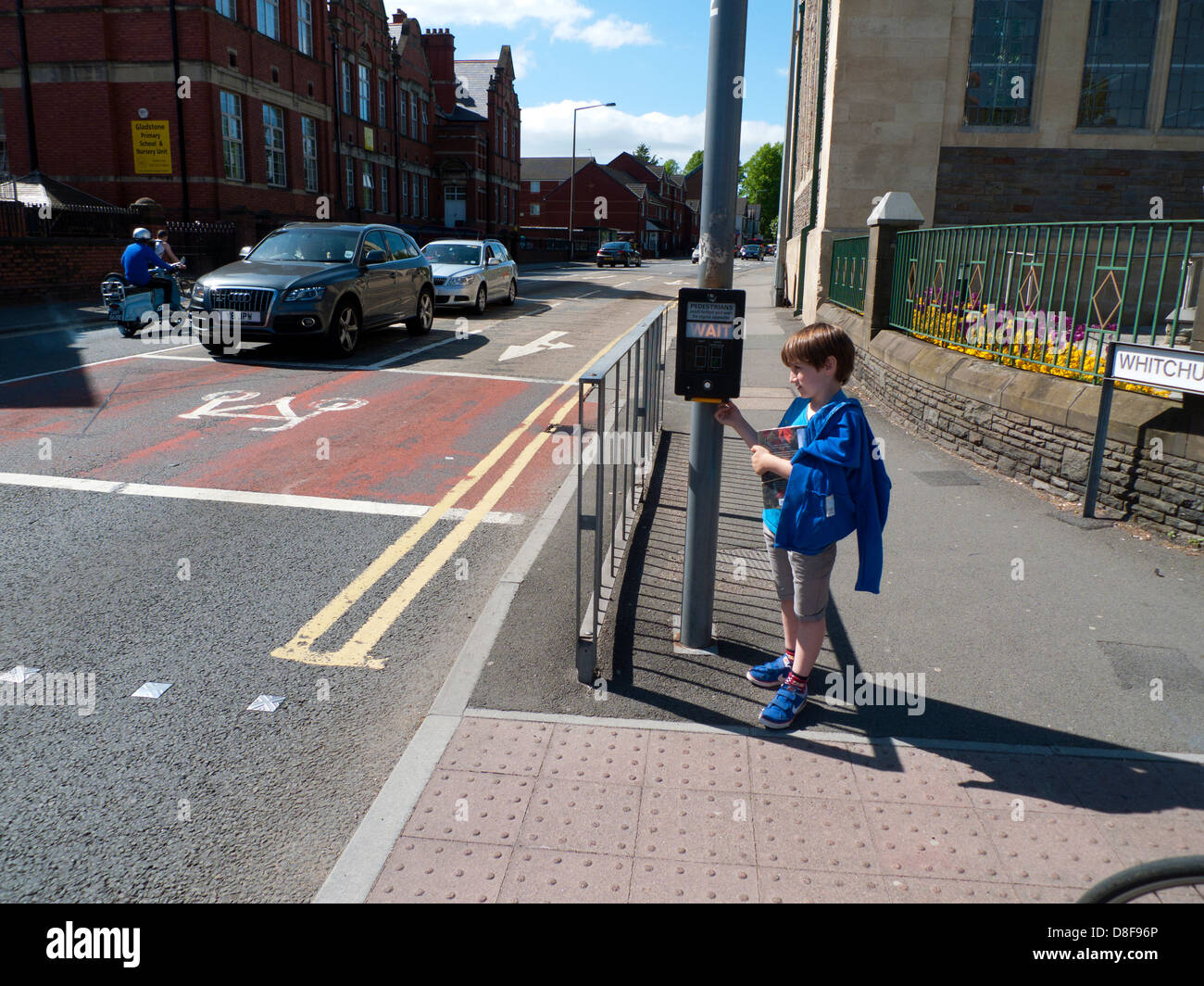 Young boy child waiting to cross the road street at traffic lights in ...