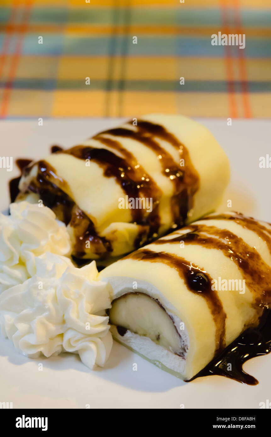 close up crepe rolls filled with white cream and banana, topping with ...