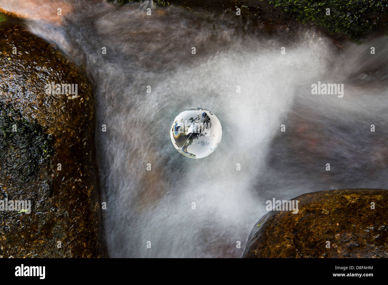 Crystal Glass globe / earth / world and rushing water in a natural ...