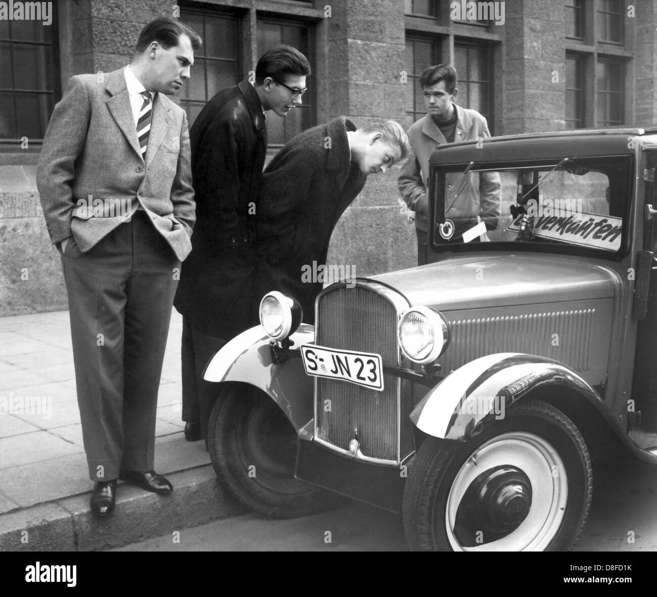 Young men have a look at an oldtimer car which is on sale in Stuttgart ...