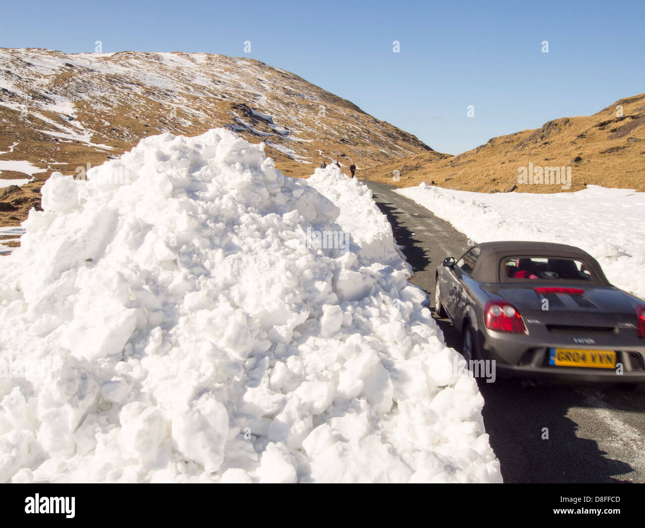 Massive snow drifts on the side of the Wrynose Pass road in the Lake ...