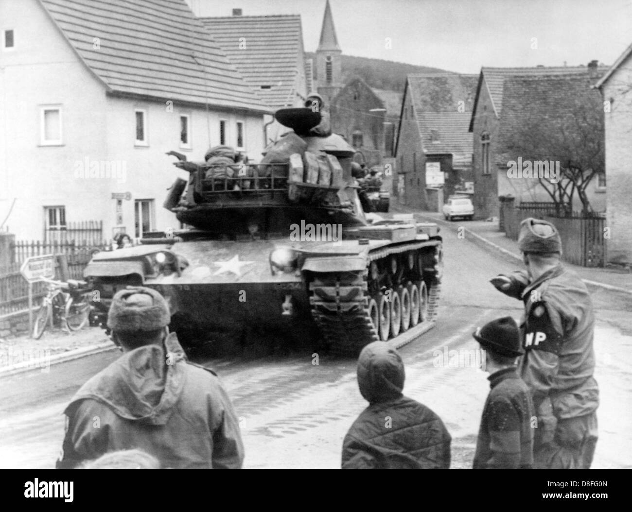 A tank of the US army drives through a small village towards the ...