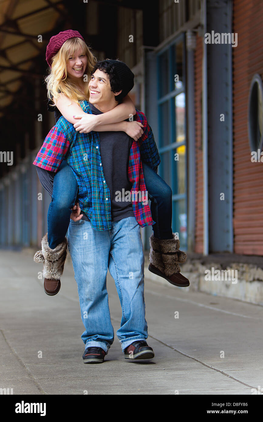 Young man giving a young woman a piggyback ride Stock Photo - Alamy