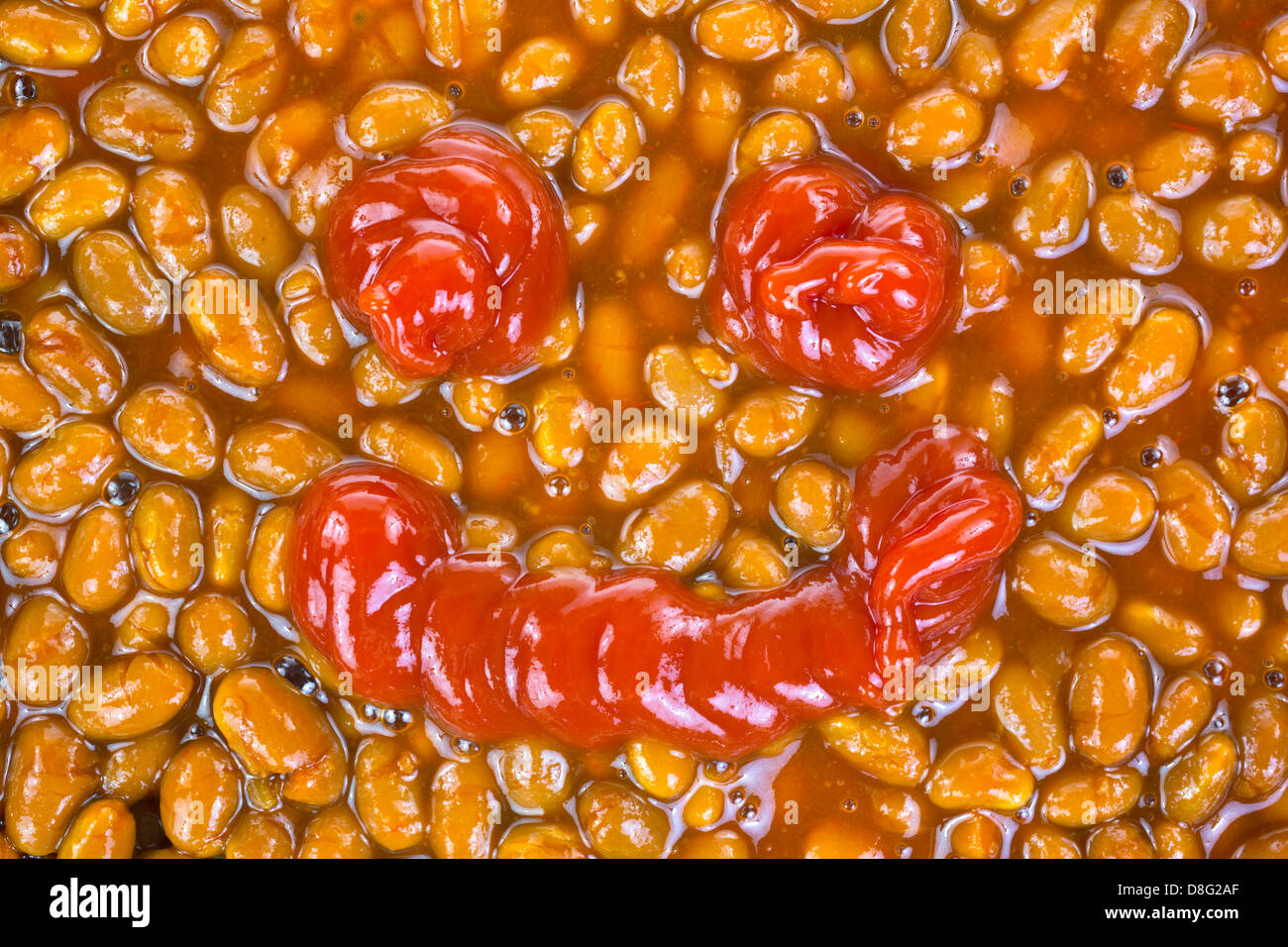 Close view of baked beans with ketchup squirted in the shape of a smile ...