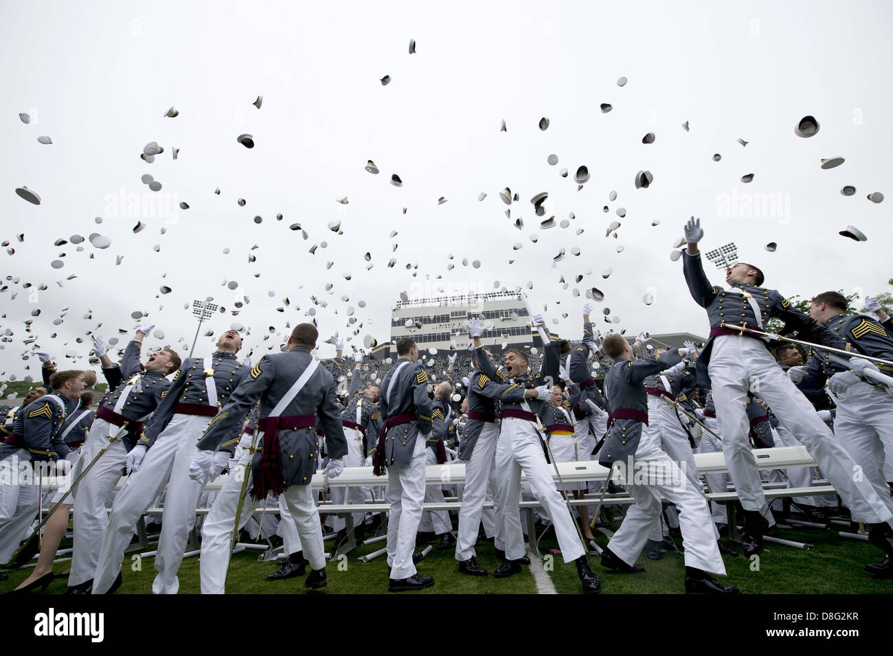 US Army cadets celebrate by throwing their hats into the air at the ...