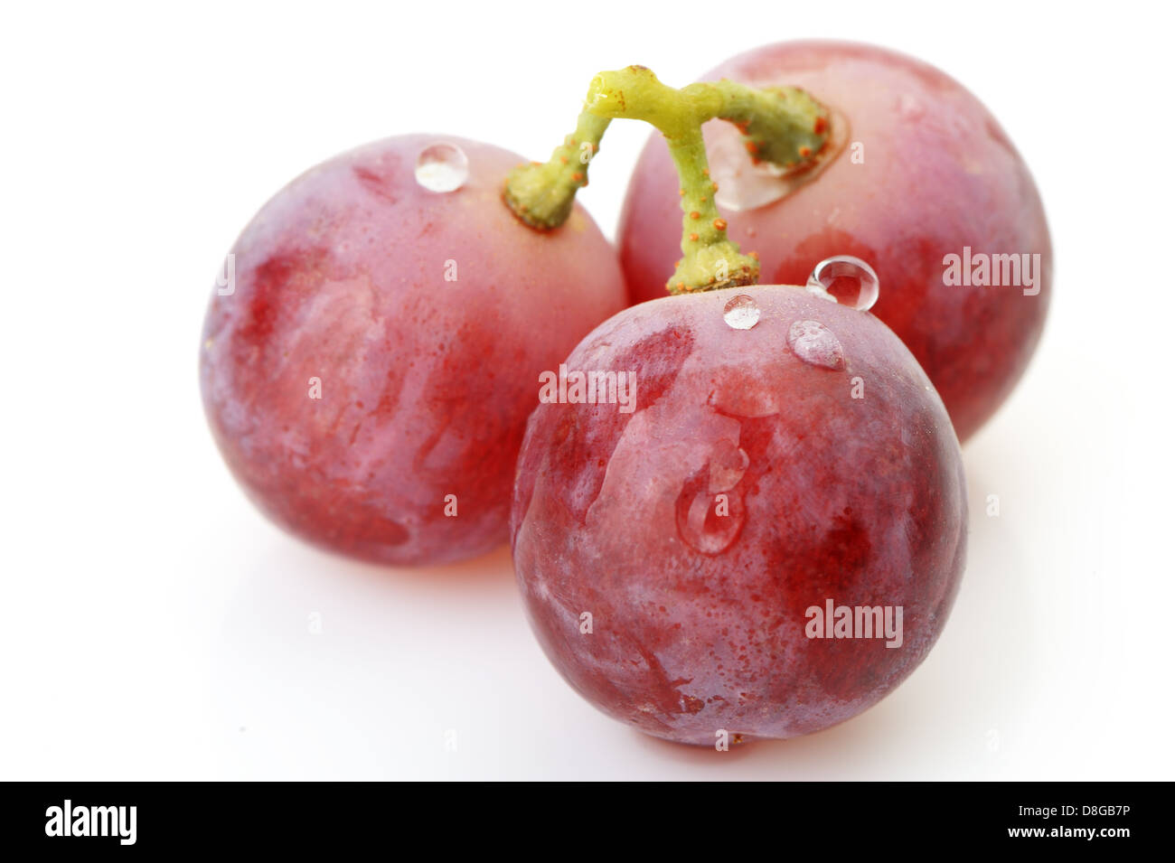 Three berries of red grapes close up Stock Photo - Alamy